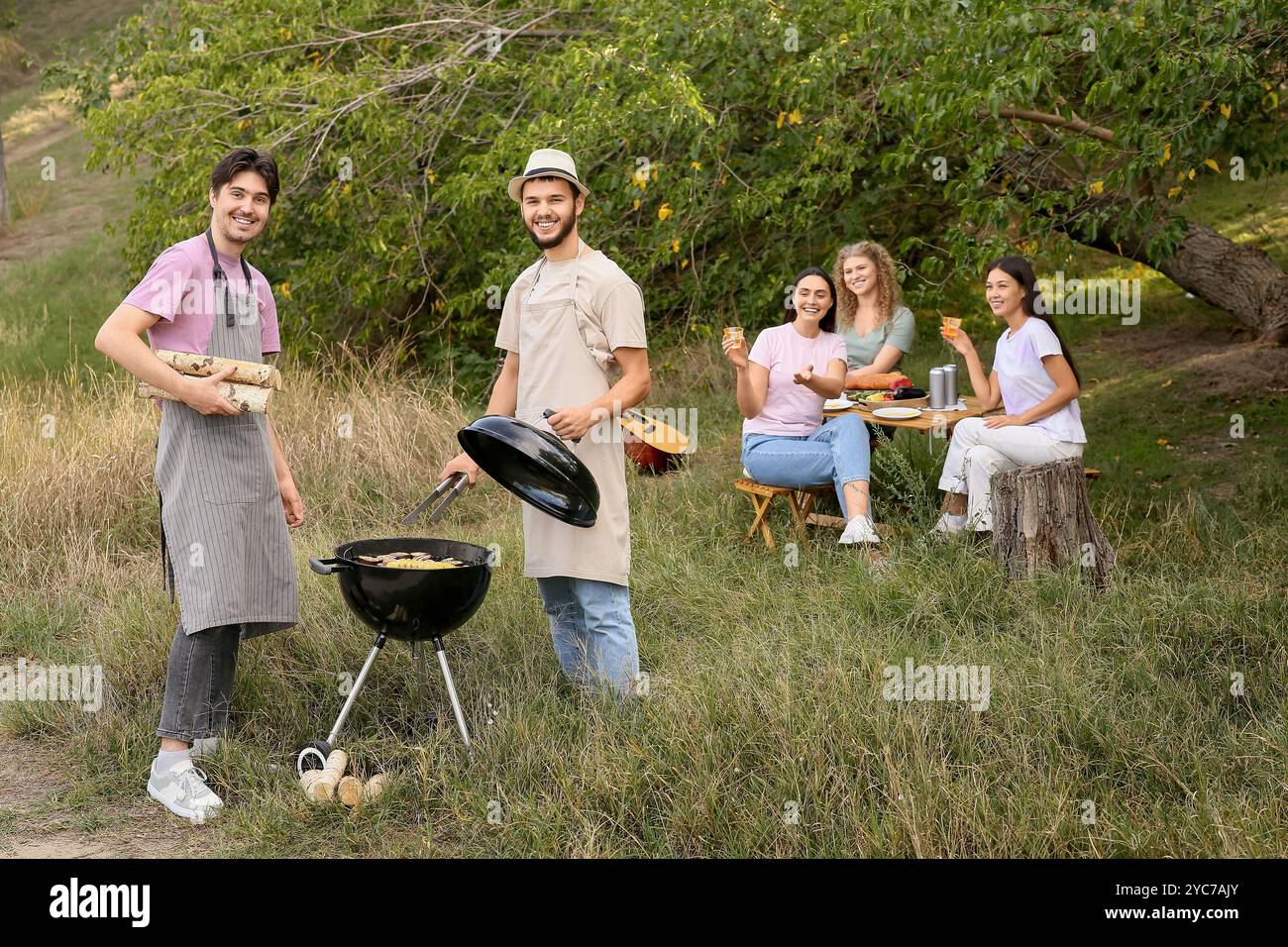 Male friends cooking food on grill at barbeque party Stock Photo - Alamy