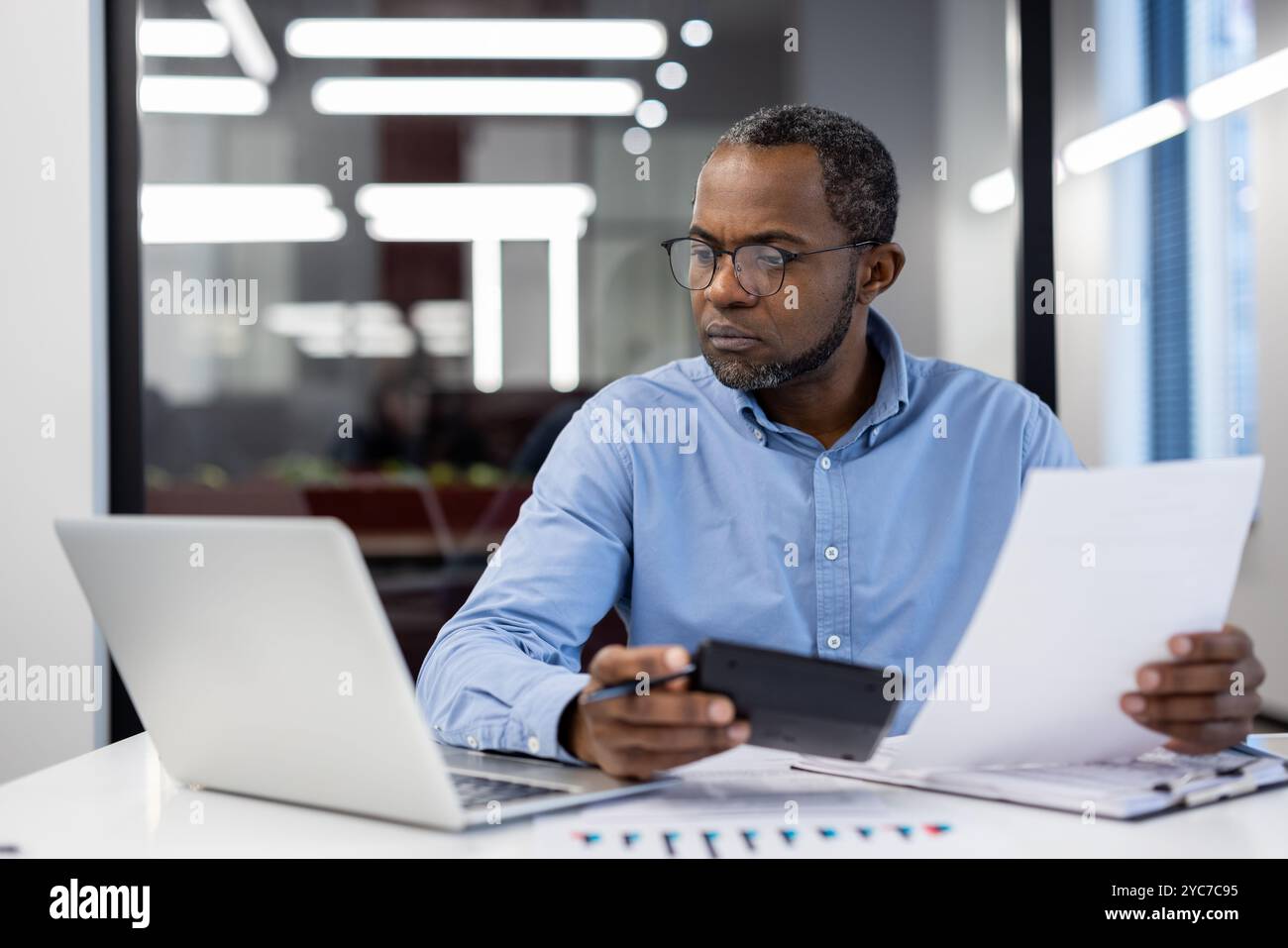 Mature african american businessman reviewing tax forms in office ...