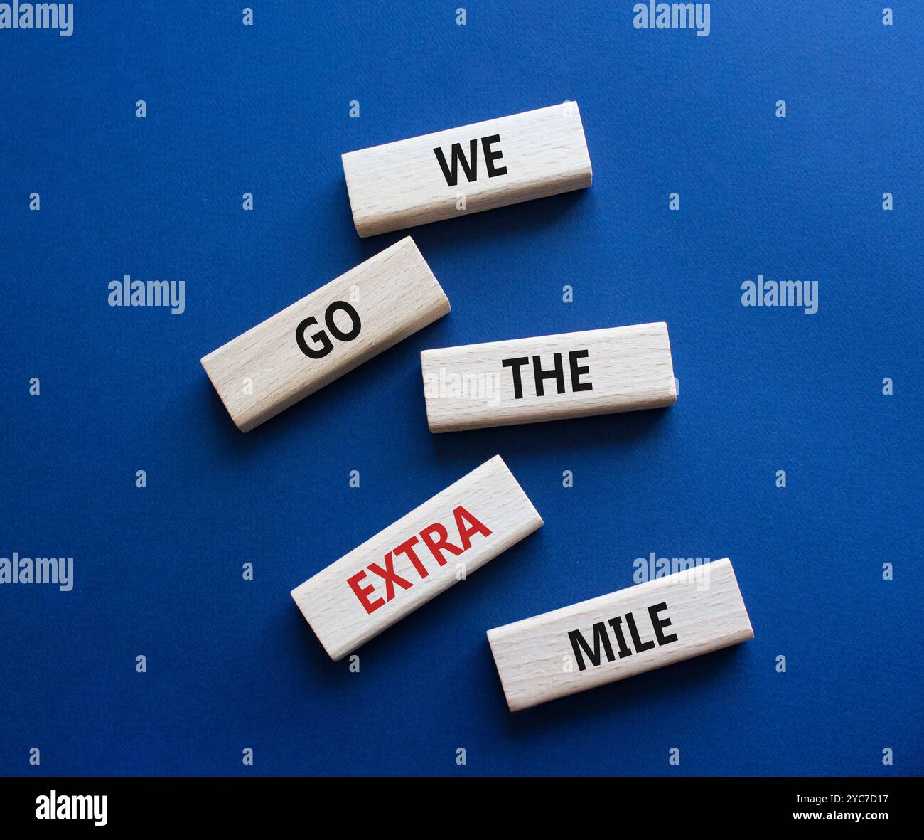 We go the extra mile symbol. Wooden blocks with words We go the extra ...