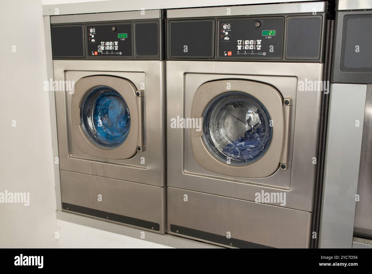 Laundry machines in a modern laundromat during the daytime Stock Photo ...
