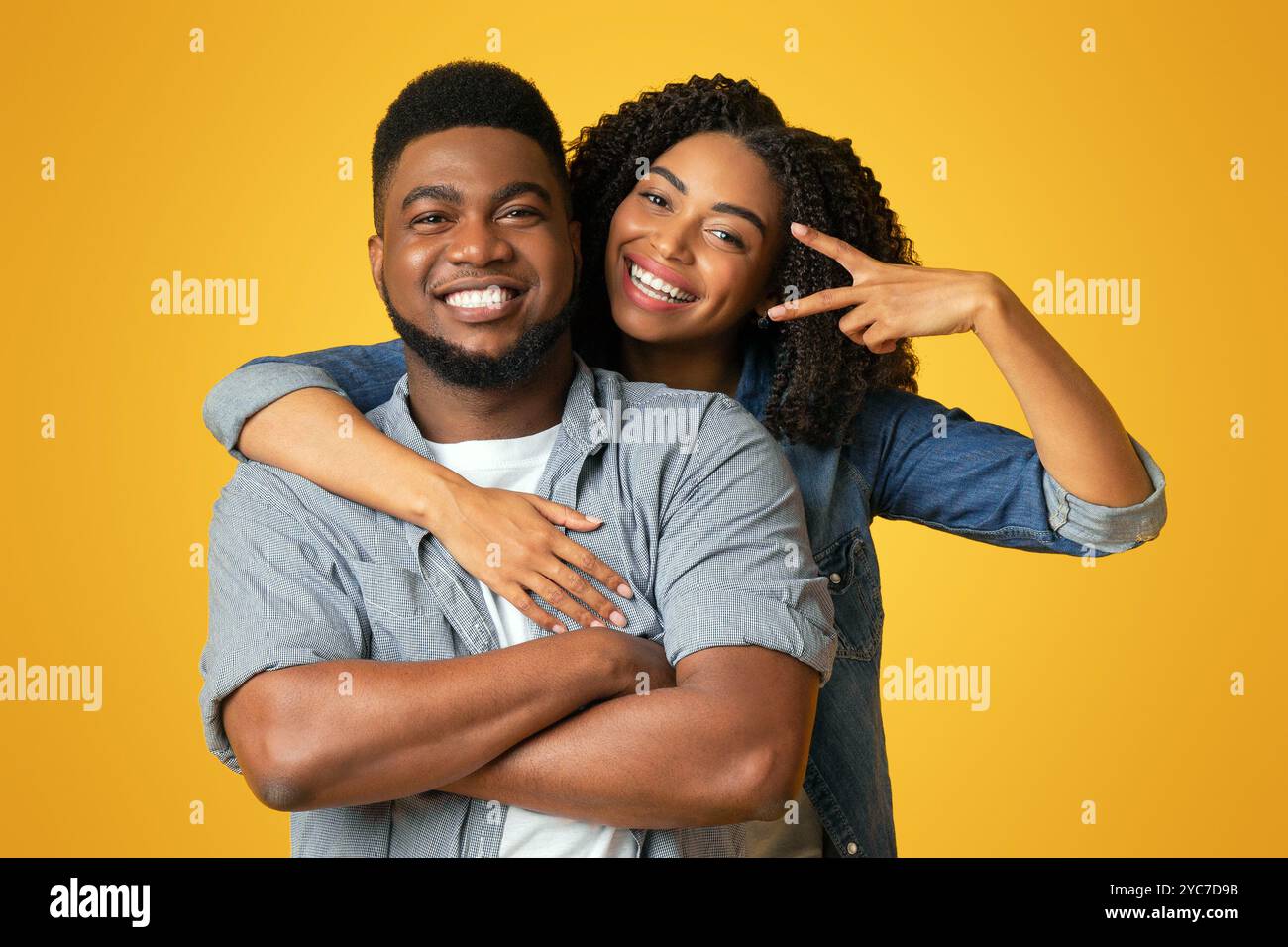 Portrait of millennial black couple embracing and posing at camera ...