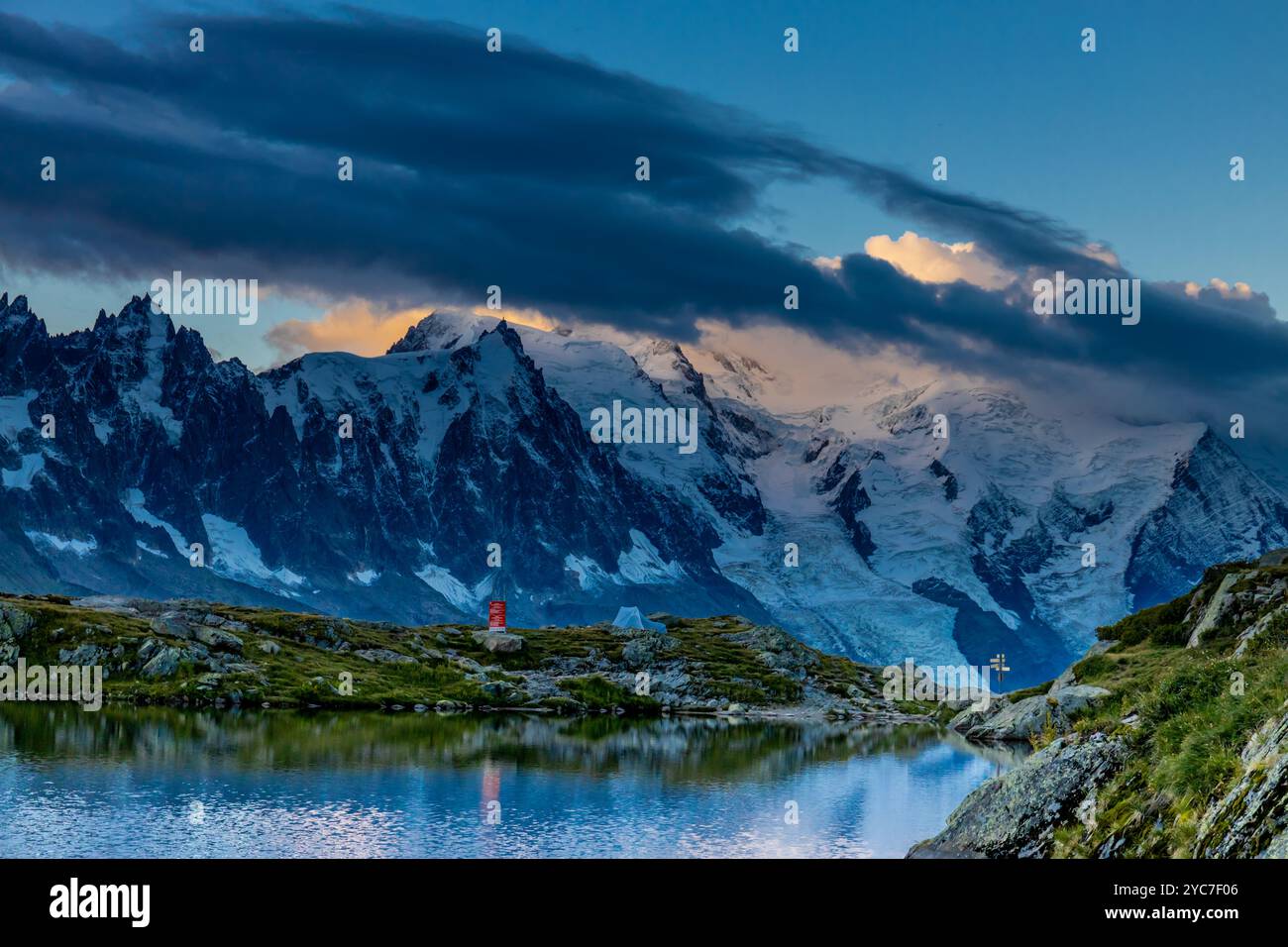 Sunset burning red and orange sky above the snow summits and rocky ...