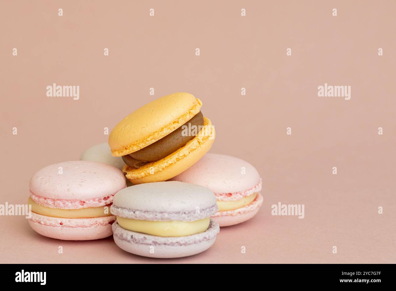 stack of macaroons on plain pink background, tasty almond dessert on ...