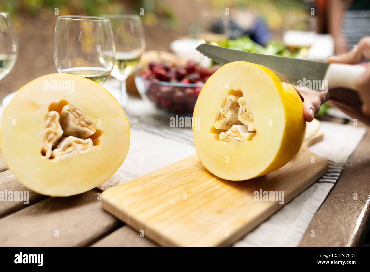 Slicing fresh squash for a summer gathering in a sunny backyard Stock ...