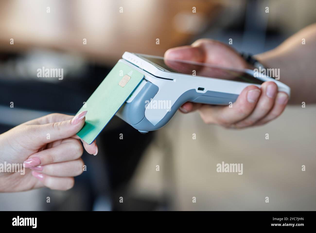 Customer paying with credit card using POS machine indoors, closeup ...