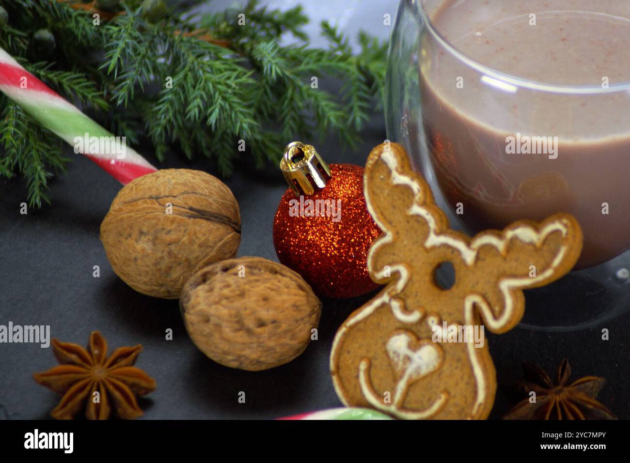 two clear glass cups filled with hot cocoa, a gingerbread cookie in the ...