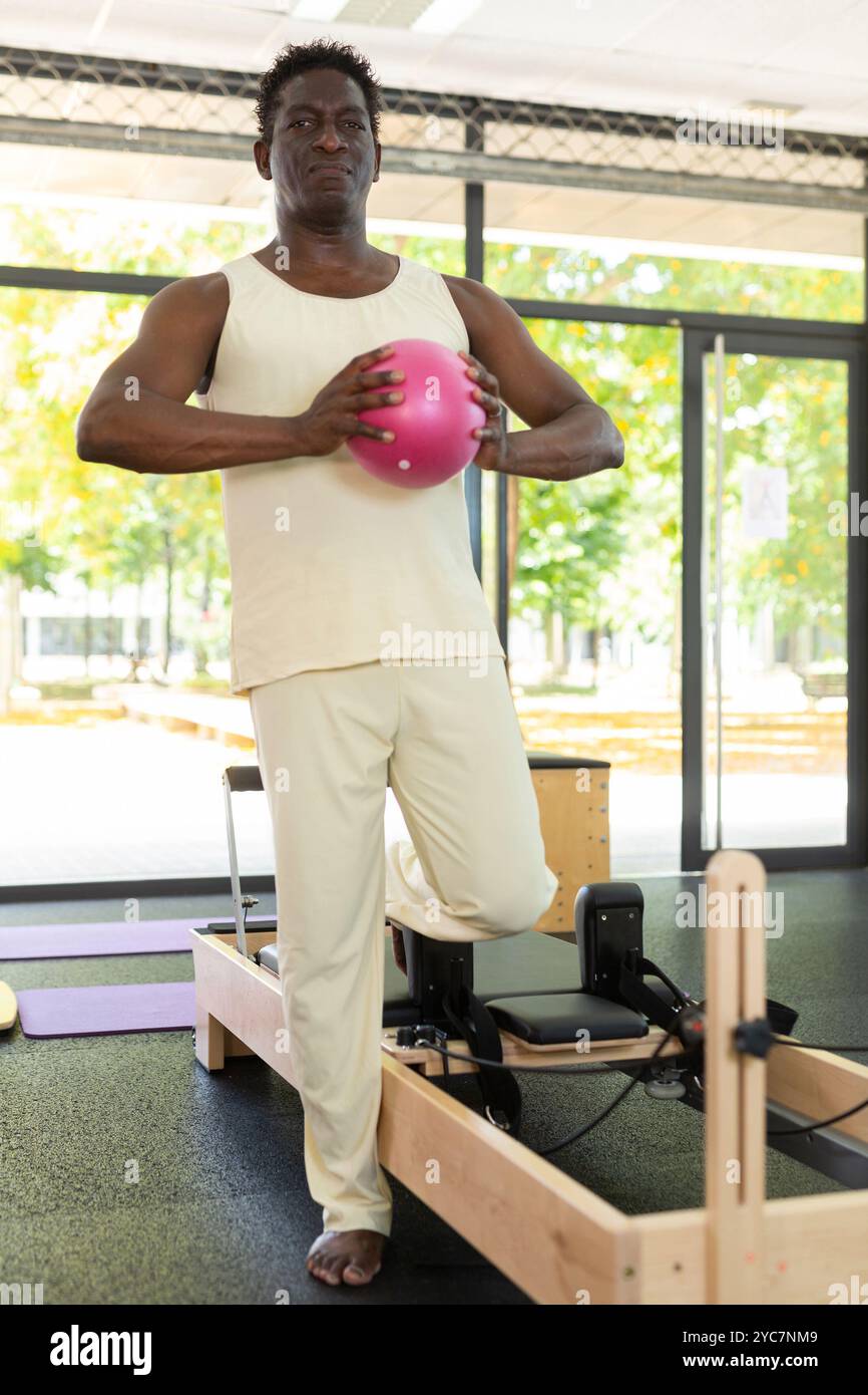 Portrait of concentrated African American man training with bender ball ...