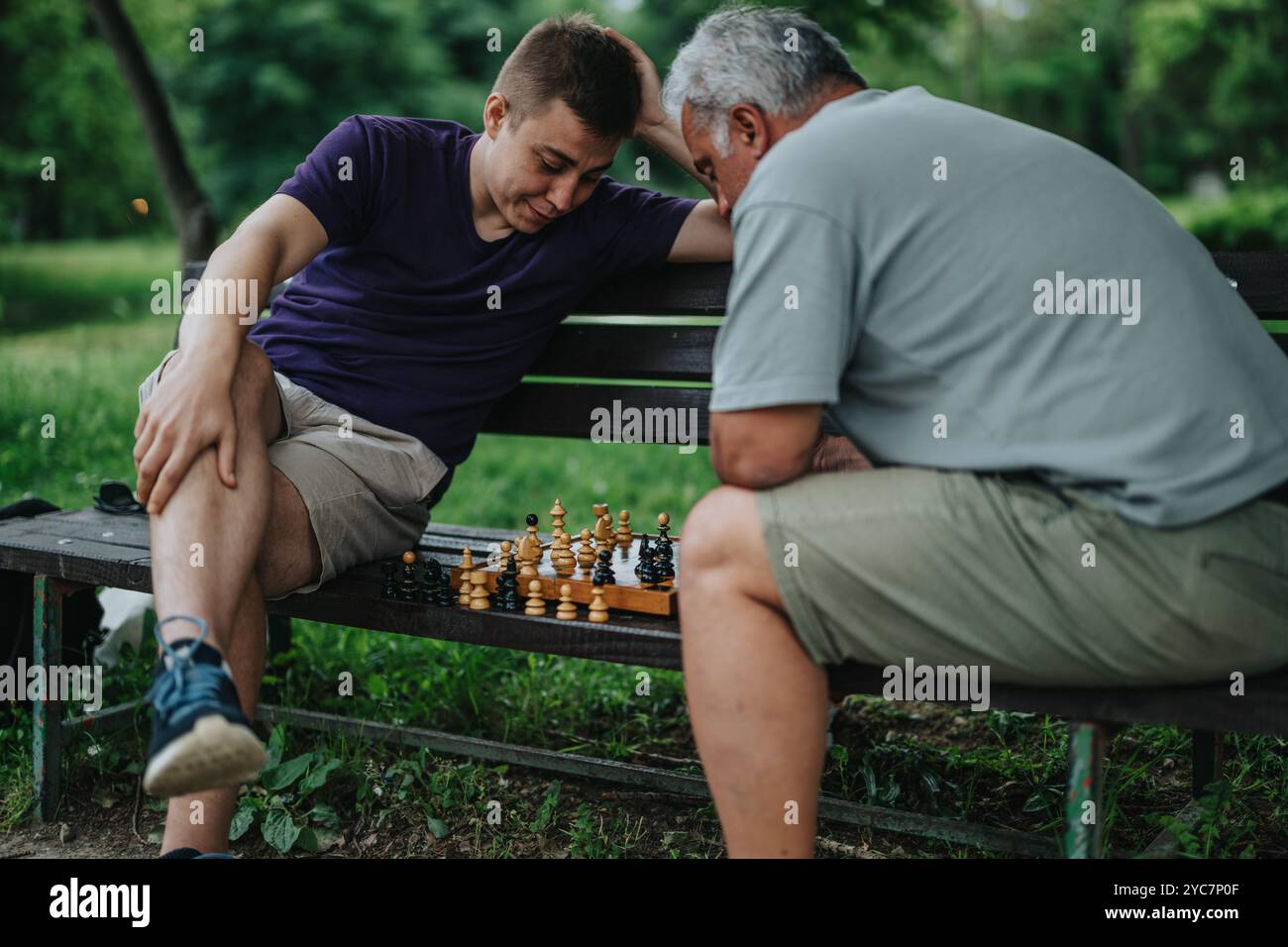 Two men engaged in a thoughtful chess game on a park bench Stock Photo ...