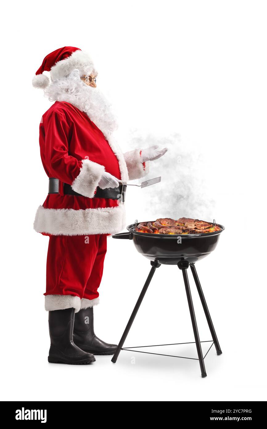 Full length profile shot of Santa claus grilling meat on bbq isolated ...