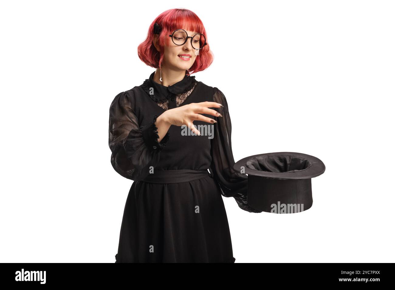 Female magician with a top hat performing a magic trick isolated on ...