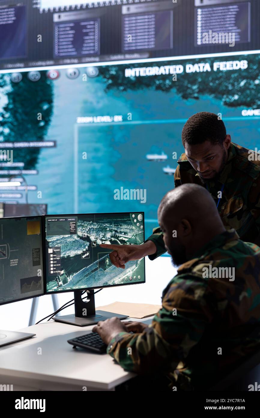 In a high tech military office, soldiers team analyze real time data ...