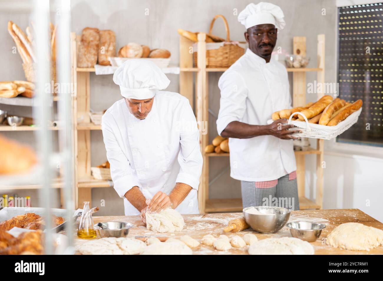 Professional baker kneading dough in artisan bakery shop Stock Photo ...