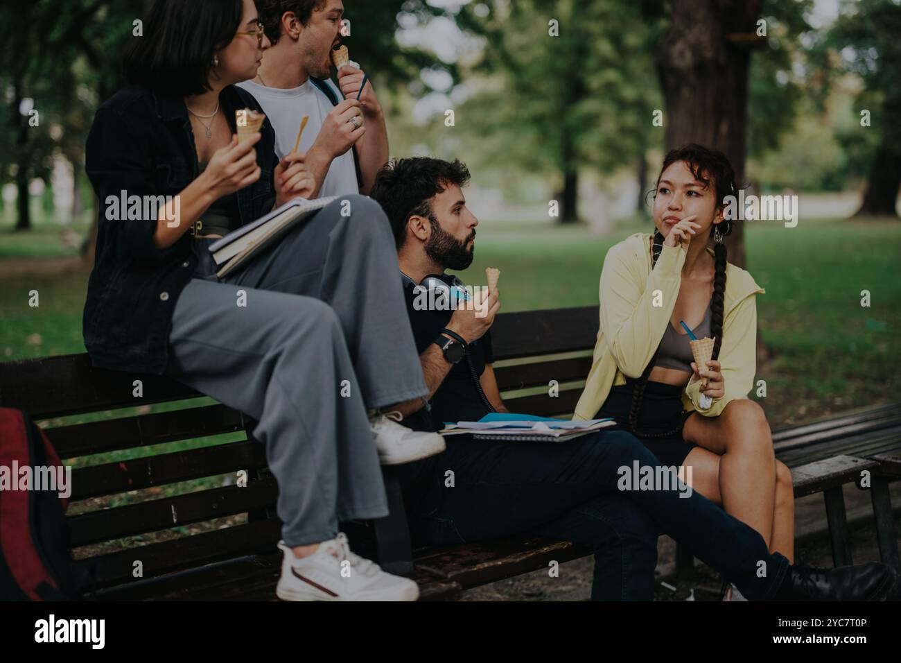 Students and professor enjoy ice cream break in the park bench Stock ...
