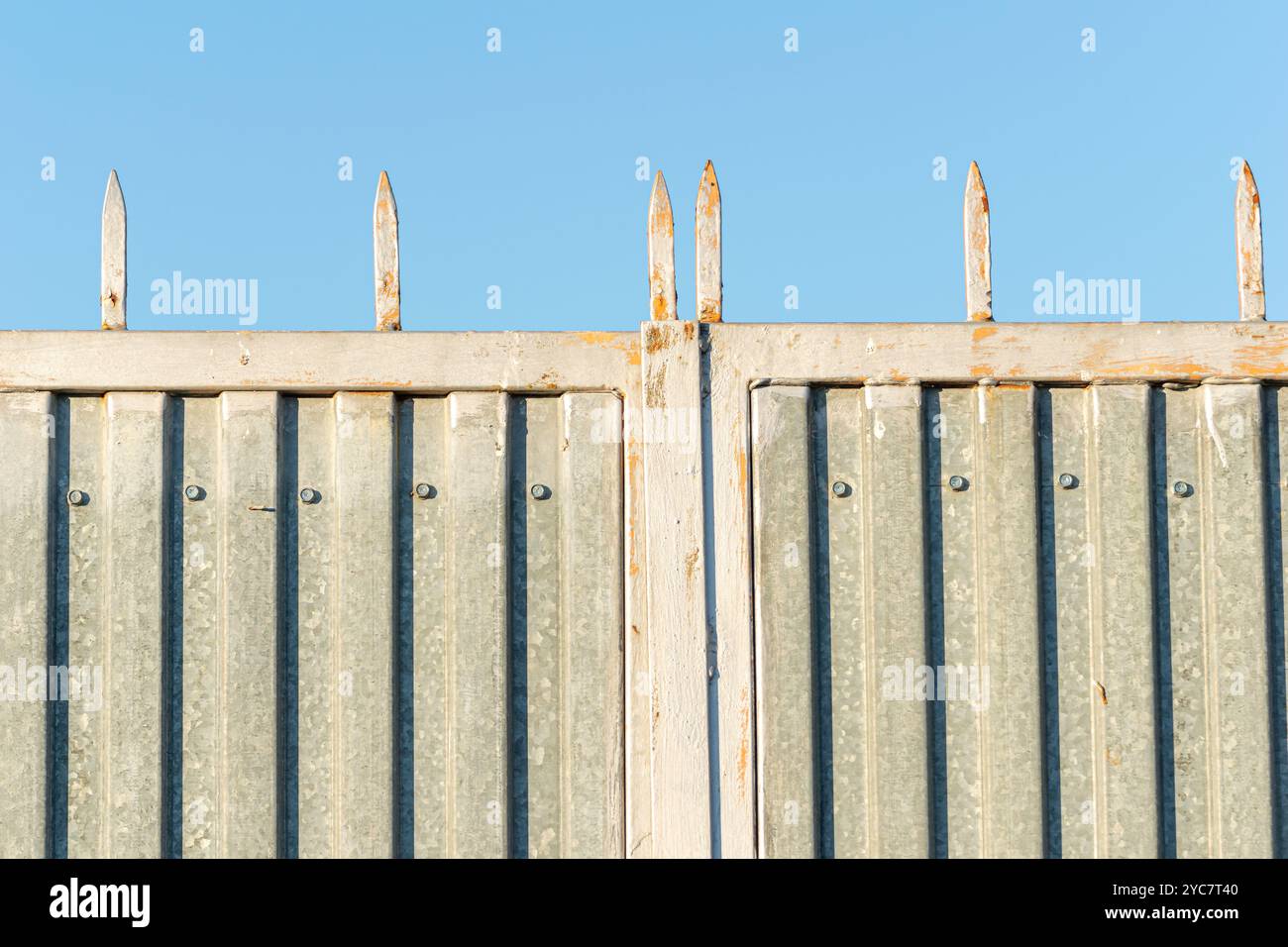 top edge of a metal gate with metal spikes, security concept background ...