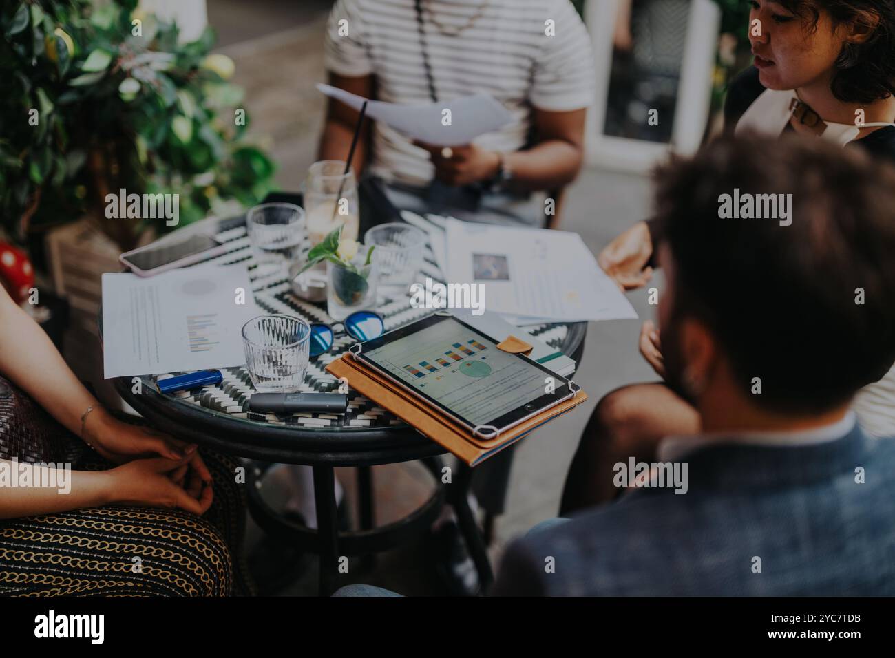 Multicultural business team strategizing in modern coffee shop Stock ...