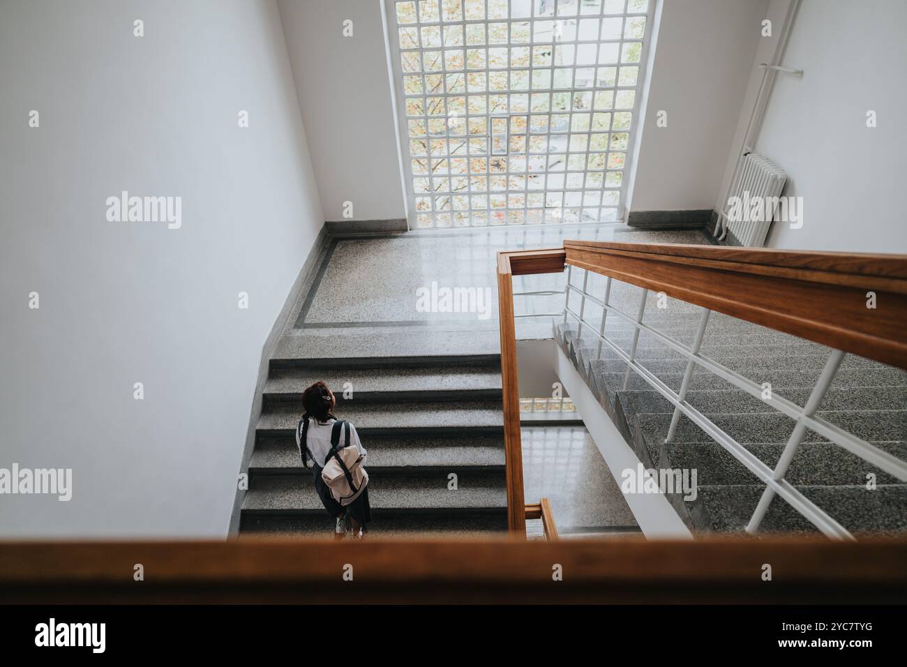 Student walking up stairs in a quiet school hallway Stock Photo - Alamy