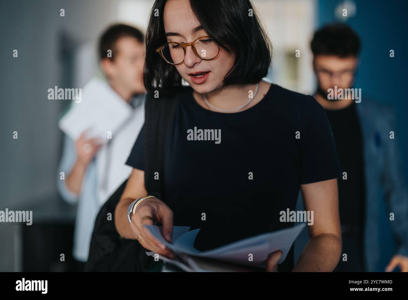 Young students reviewing documents outdoors with professor Stock Photo ...
