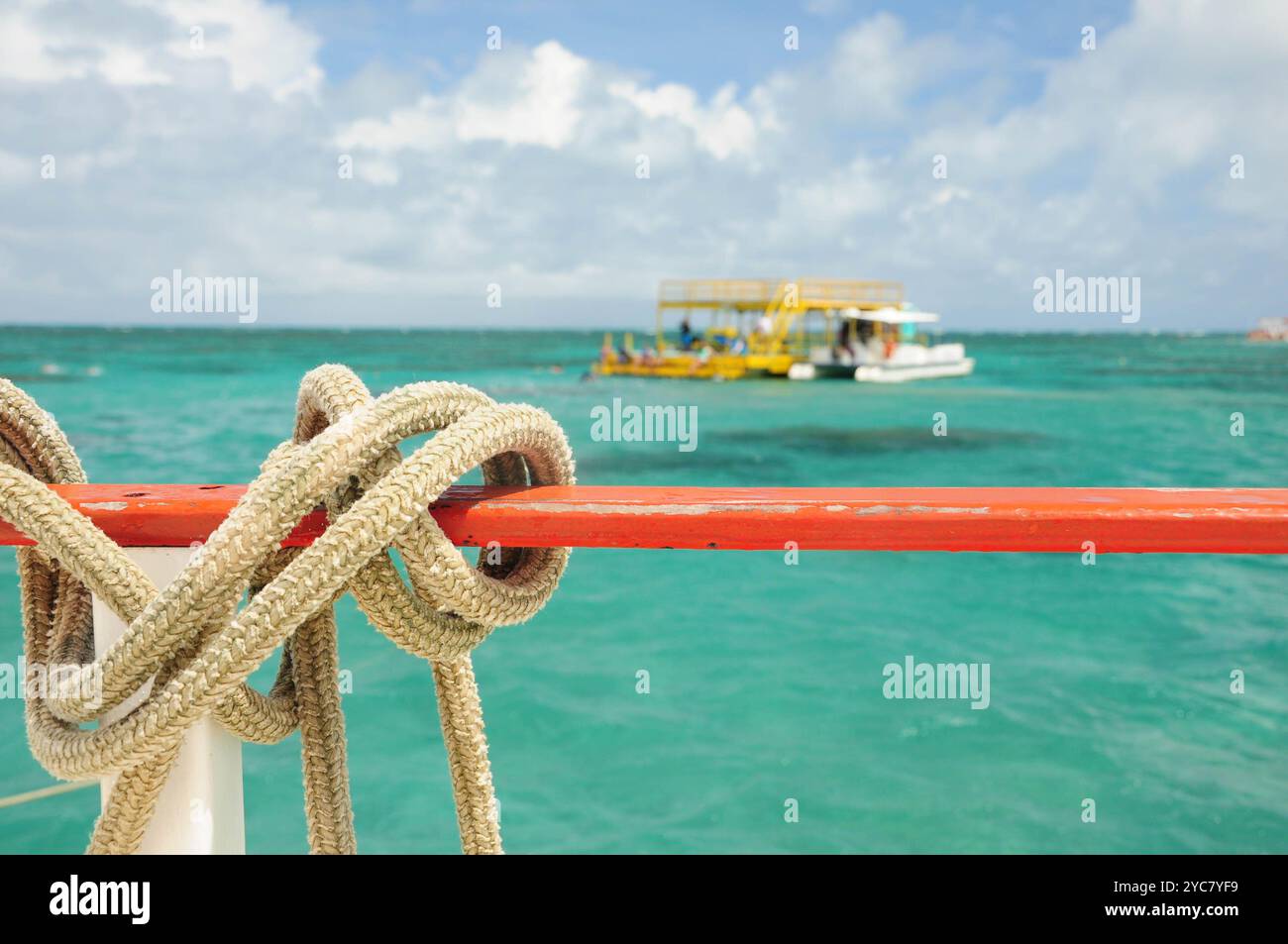 Rope on boat with turquoise ocean and floating raft in background Stock ...