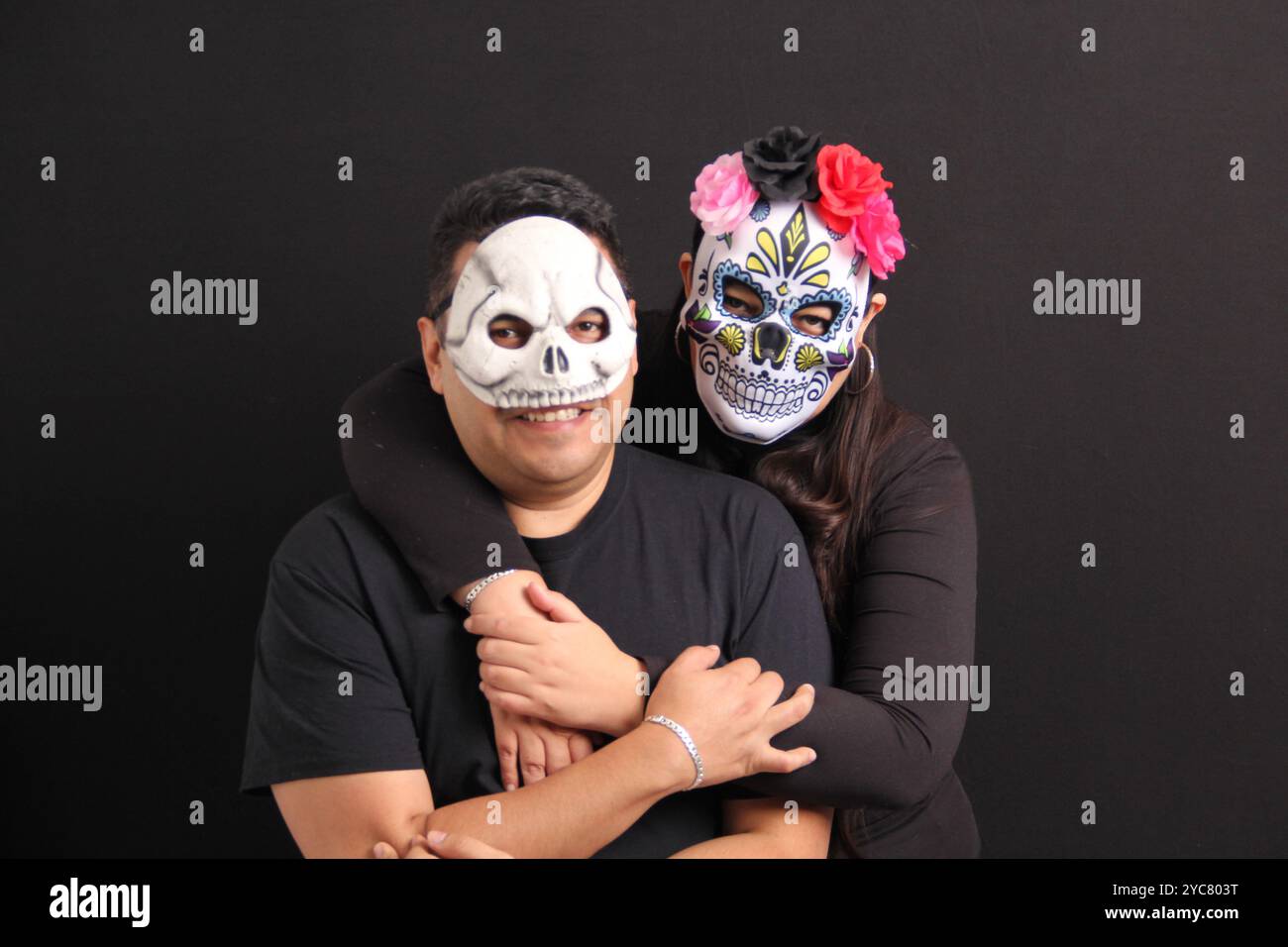 Couple of Mexican man and woman wear skull masks as costumes to ...