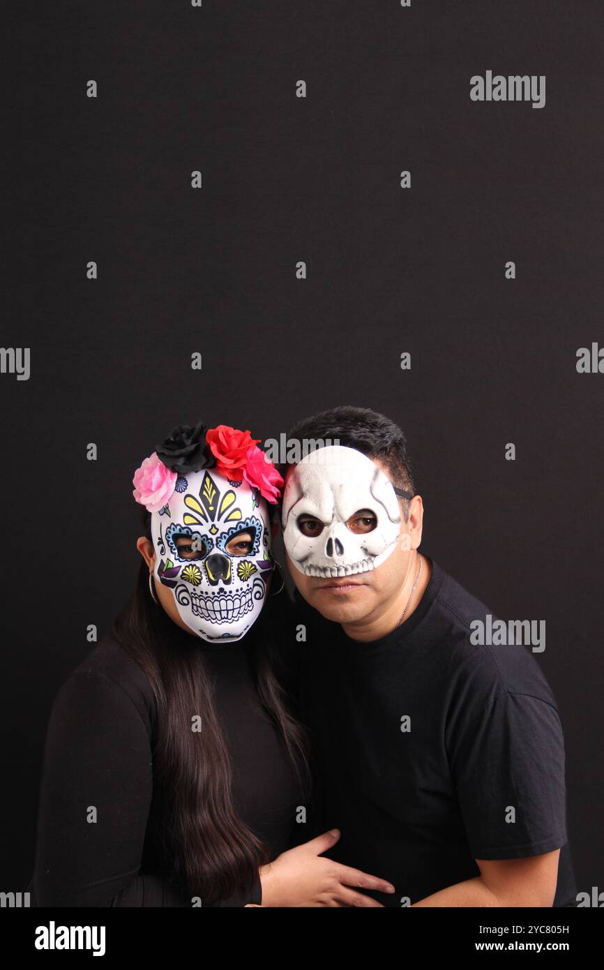 Couple of Mexican man and woman wear skull masks as costumes to ...