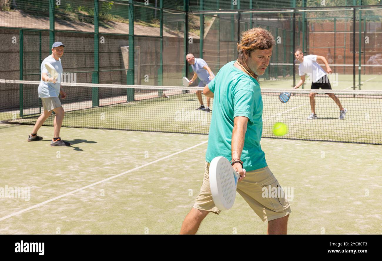 Adult men playing padel against two men Stock Photo - Alamy