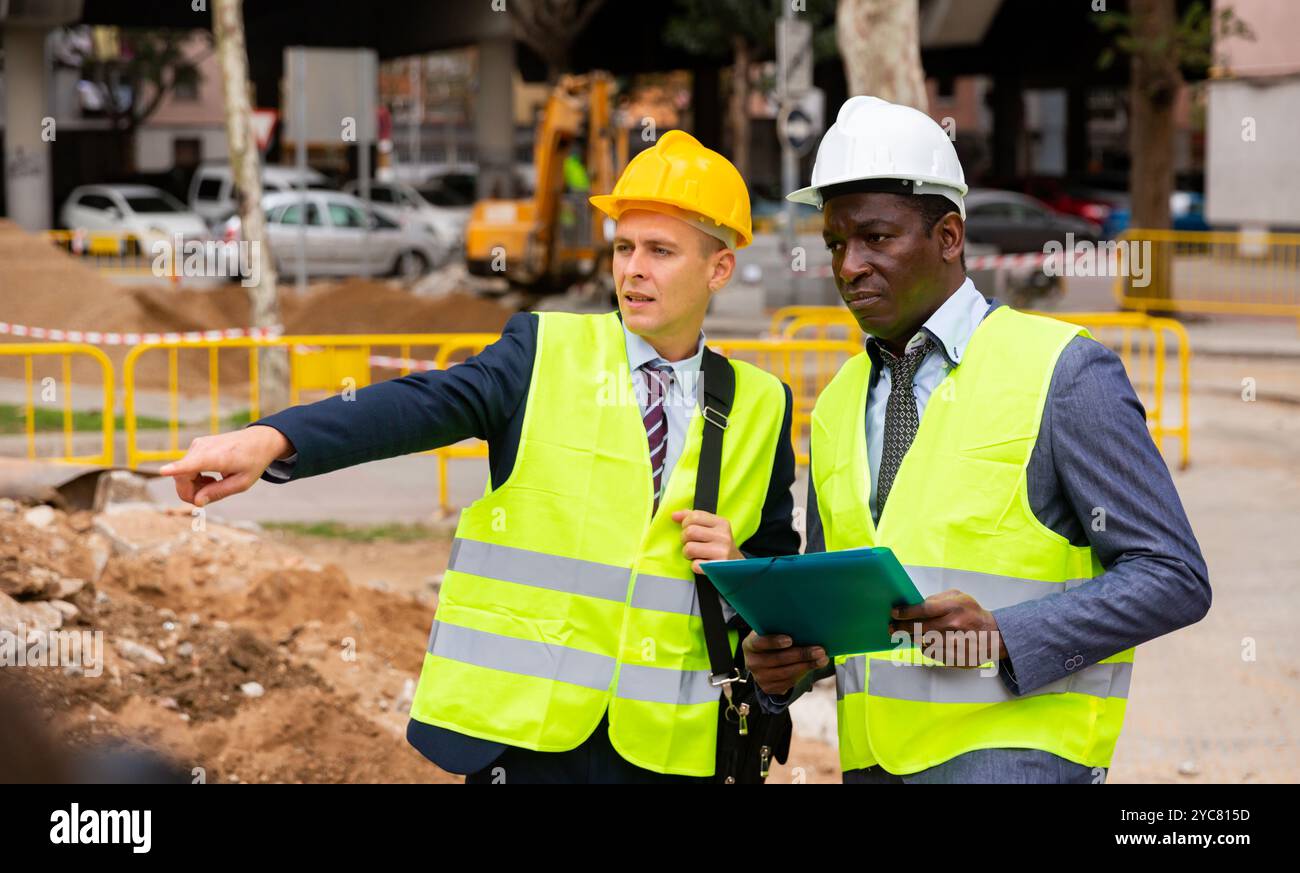 Two engineers talking about road repairing works Stock Photo - Alamy