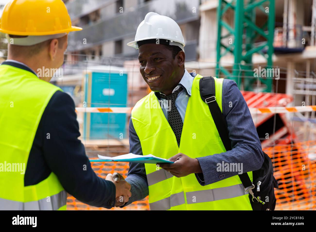 Two confident civil engineers exchange a friendly handshake Stock Photo ...