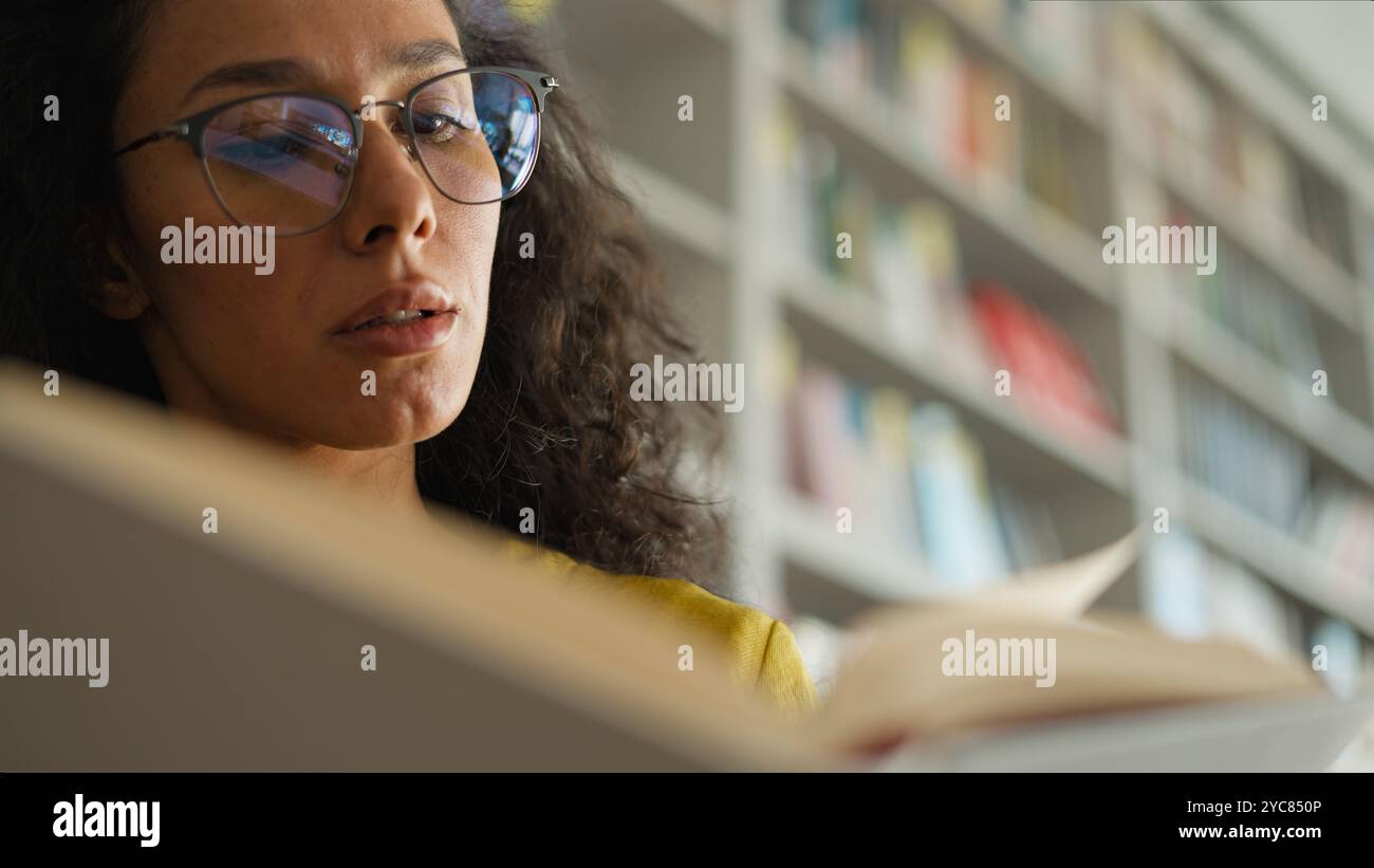 Hispanic Arab Indian woman girl student reading book novel textbook literature hobby reader ...