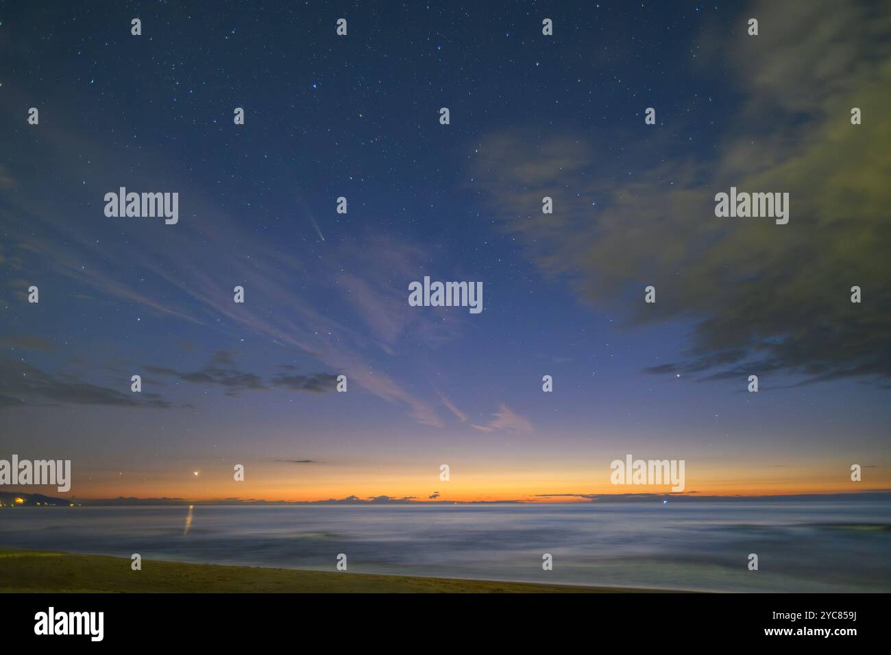 The coastal sunset turns into a starry night. In the sky comet C/2023 ...