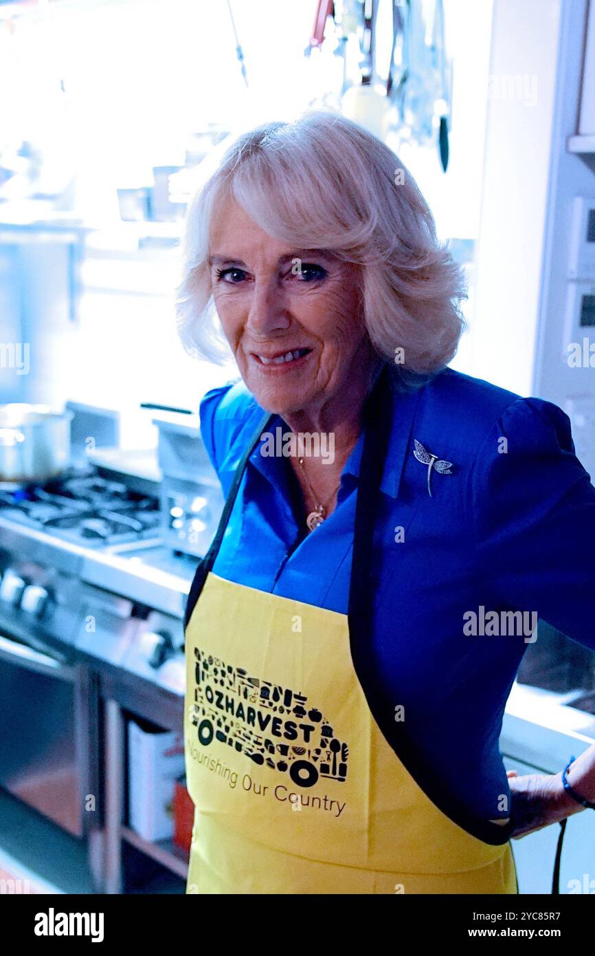 Queen Camilla ties an apron as she assists with meal preparation during ...