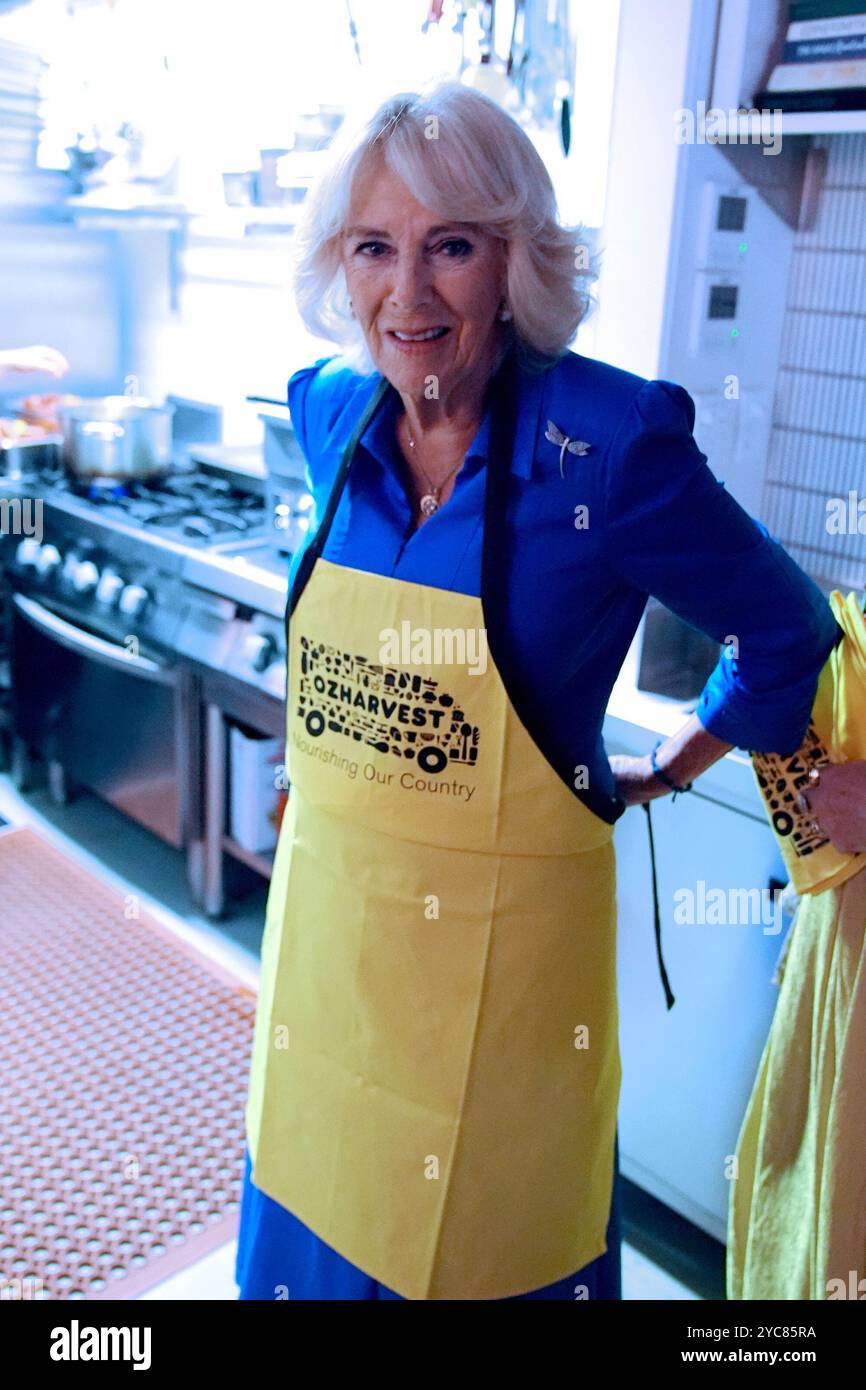 Queen Camilla ties an apron as she assists with meal preparation during ...