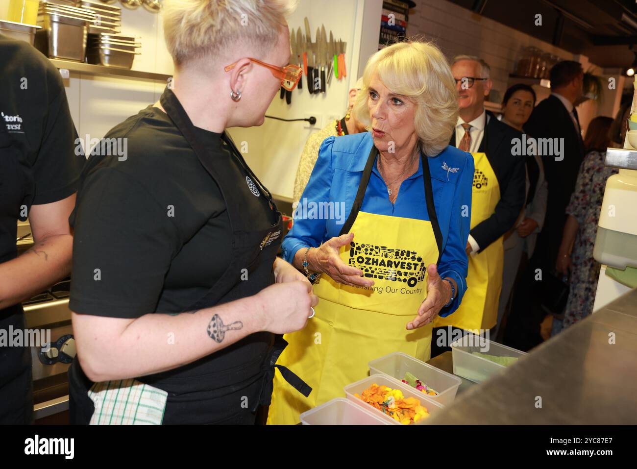 Queen Camilla wears an apron as she assists with meal preparation ...