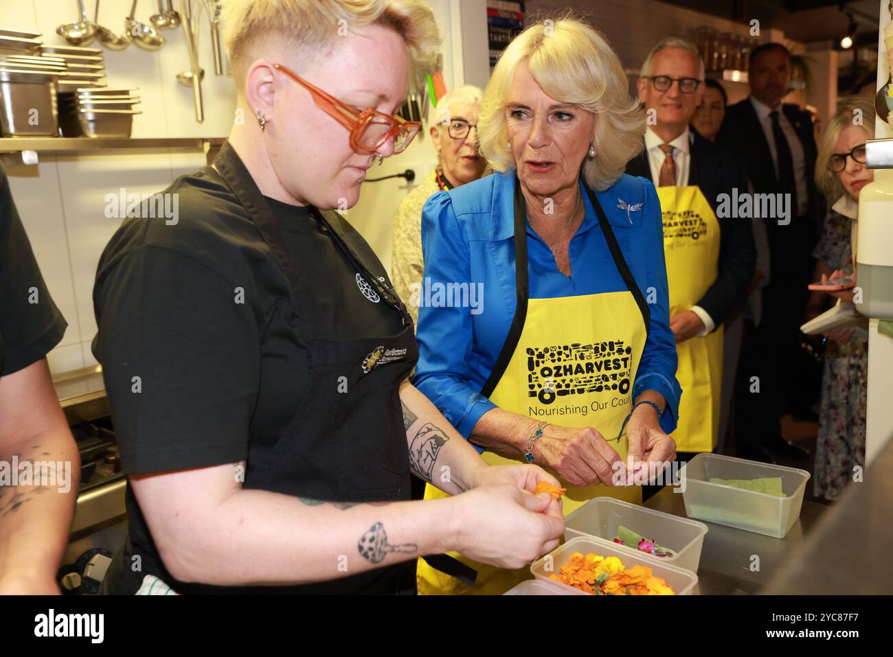 Queen Camilla wears an apron as she assists with meal preparation ...
