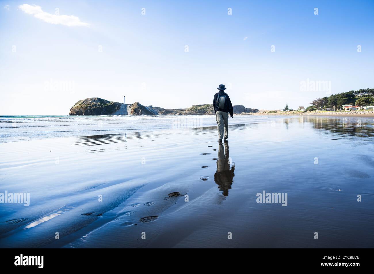 Man walking on Castlepoint beach. Footprints and reflection on the wet ...