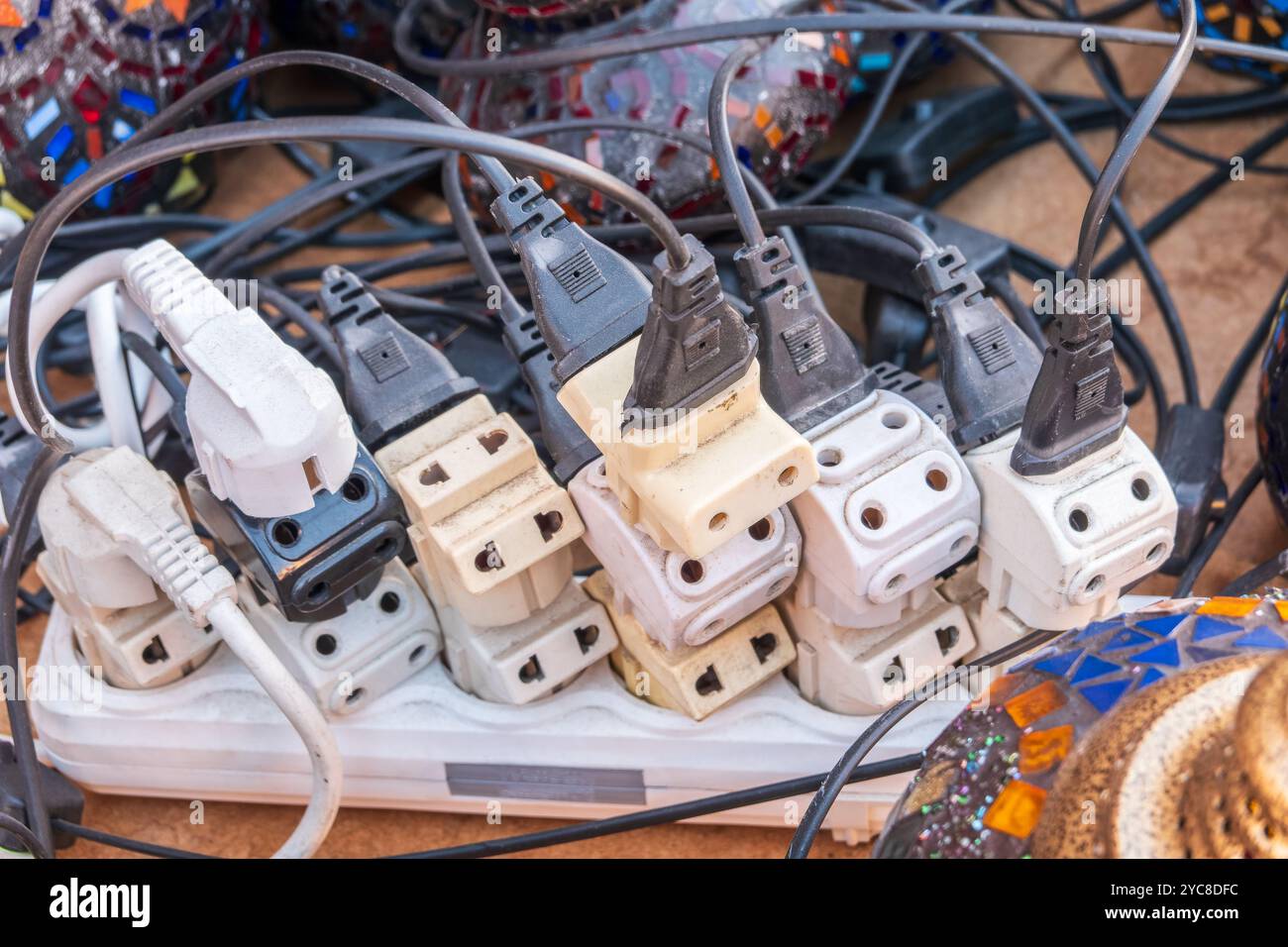 Old and damaged electric adapter power plug has many appliances are ...