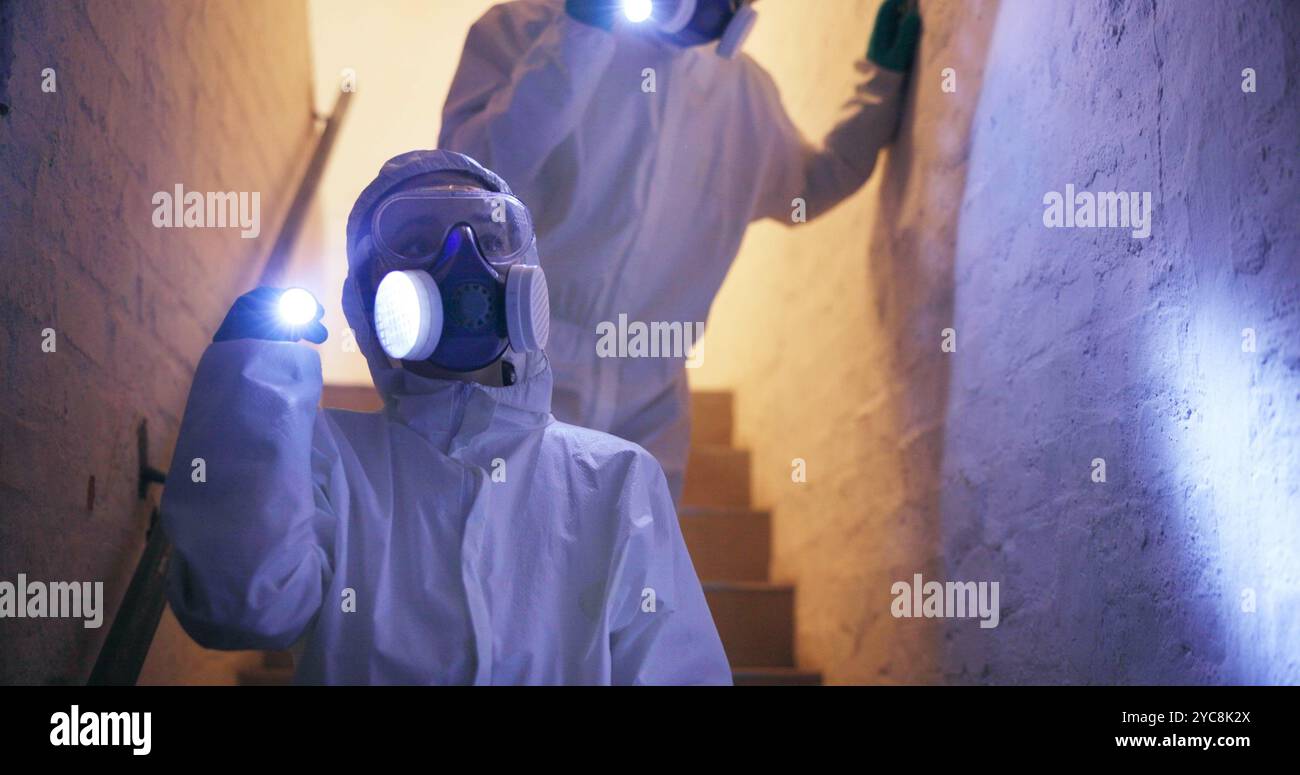 Hazmat, suit or people for safety walking with flashlight in basement ...