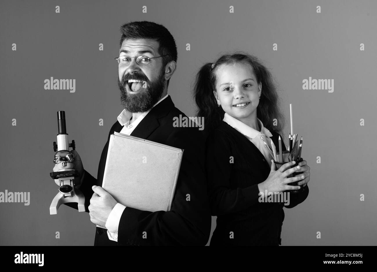 Amazed teacher with excited happy pupil school girl. Portrait of funny ...