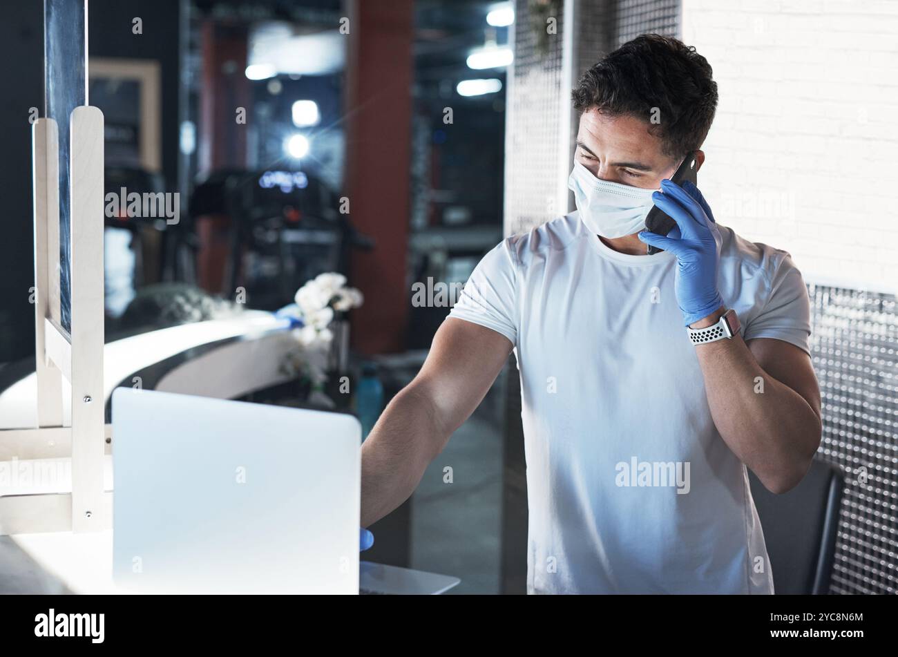 Safety, mask and man at gym with phone call, laptop or compliance for ...