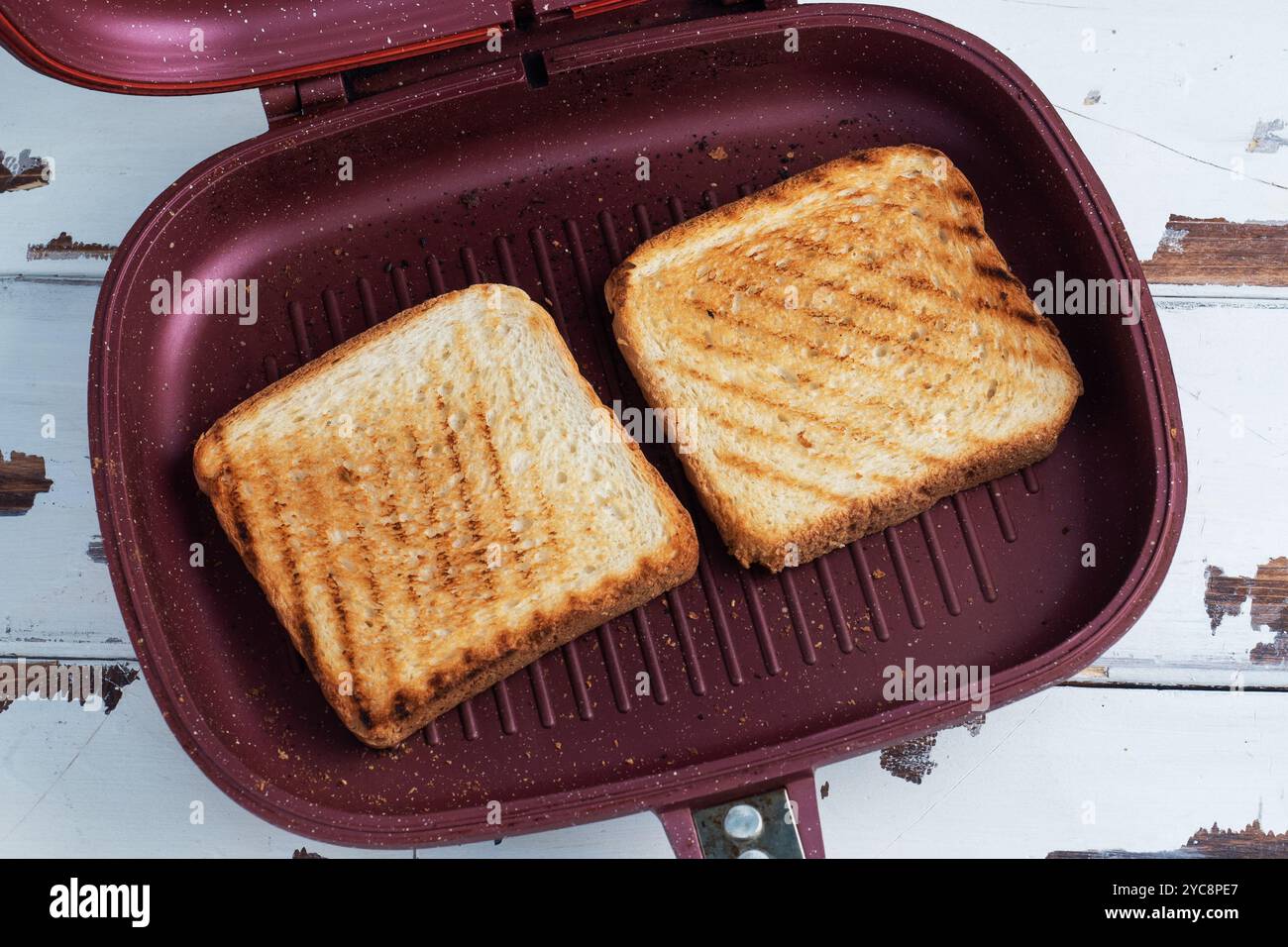 Two pieces of toasted bread in a grill pan. Close up Stock Photo - Alamy