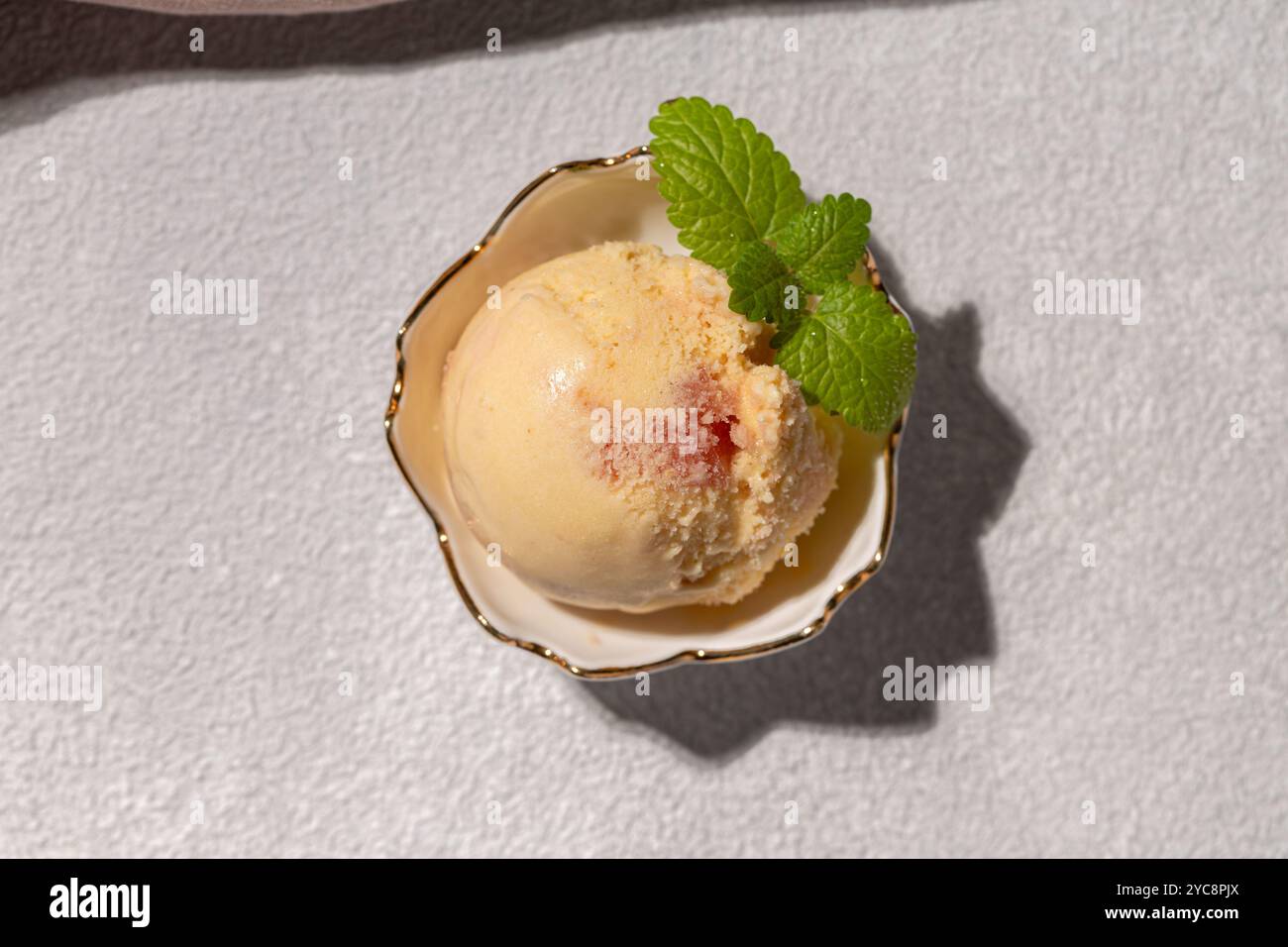 A ball of peach ice cream with a mint leaf in a beautiful creamer Stock ...