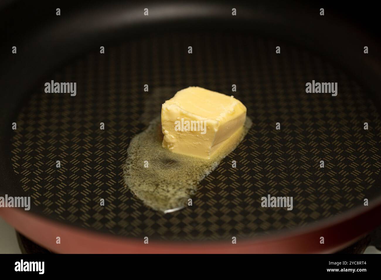 A piece of butter is melted in a non-stick frying pan, close-up Stock ...