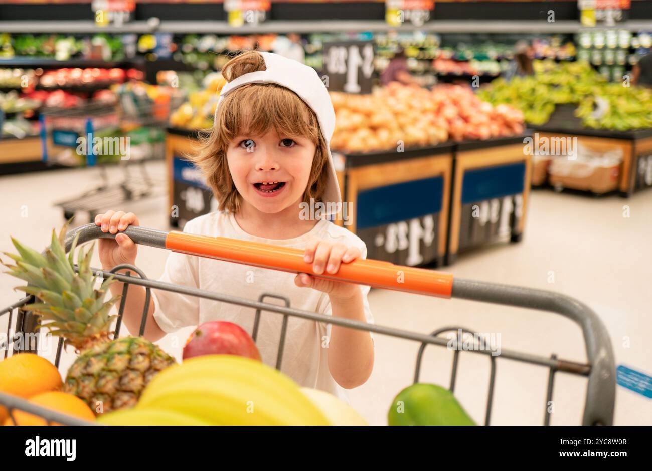 Toddler boy with shopping bag in supermarket. Child shopping in ...