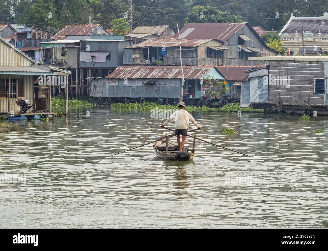 A man is rowing his small wooden boat across the Bassac River, Chau Doc ...