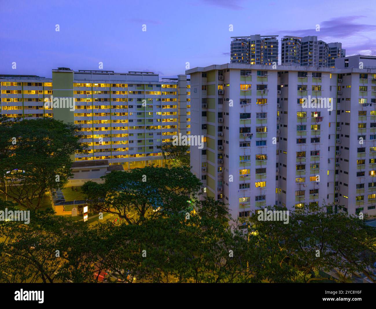Illuminated high-rise HDB apartment buildings amidst greenery in ...