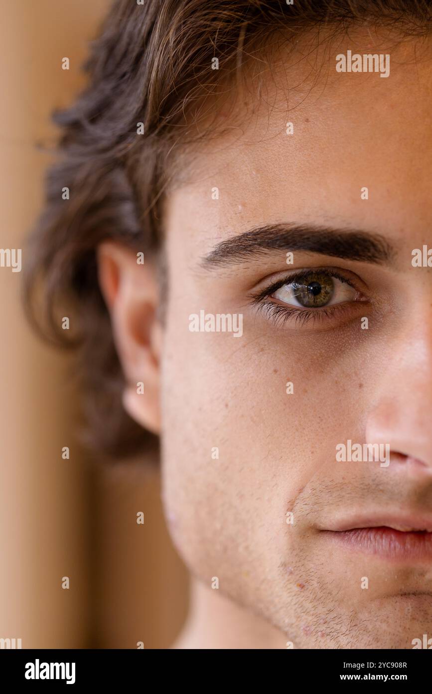 Close-up of young man with thoughtful expression, focusing on his eye ...