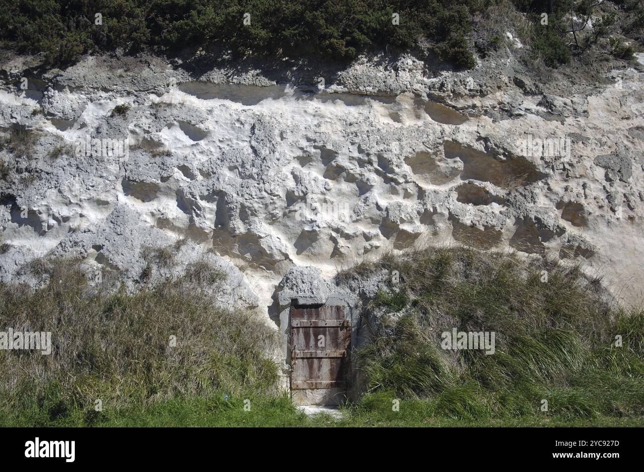 Old iron door set in a cliff face, Dunedin, South Island, New Zealand ...