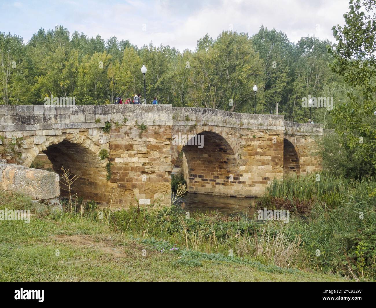 Camino pilgrims walk on the Singing Bridge (Puente Canto), an 11th ...