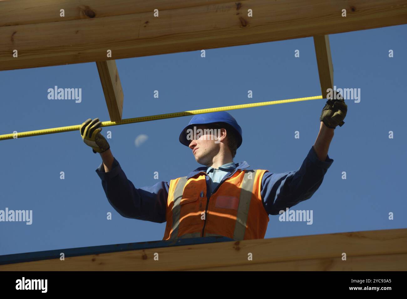 GREYMOUTH, NEW ZEALAND, circa 2015: A builder measures the length of ...
