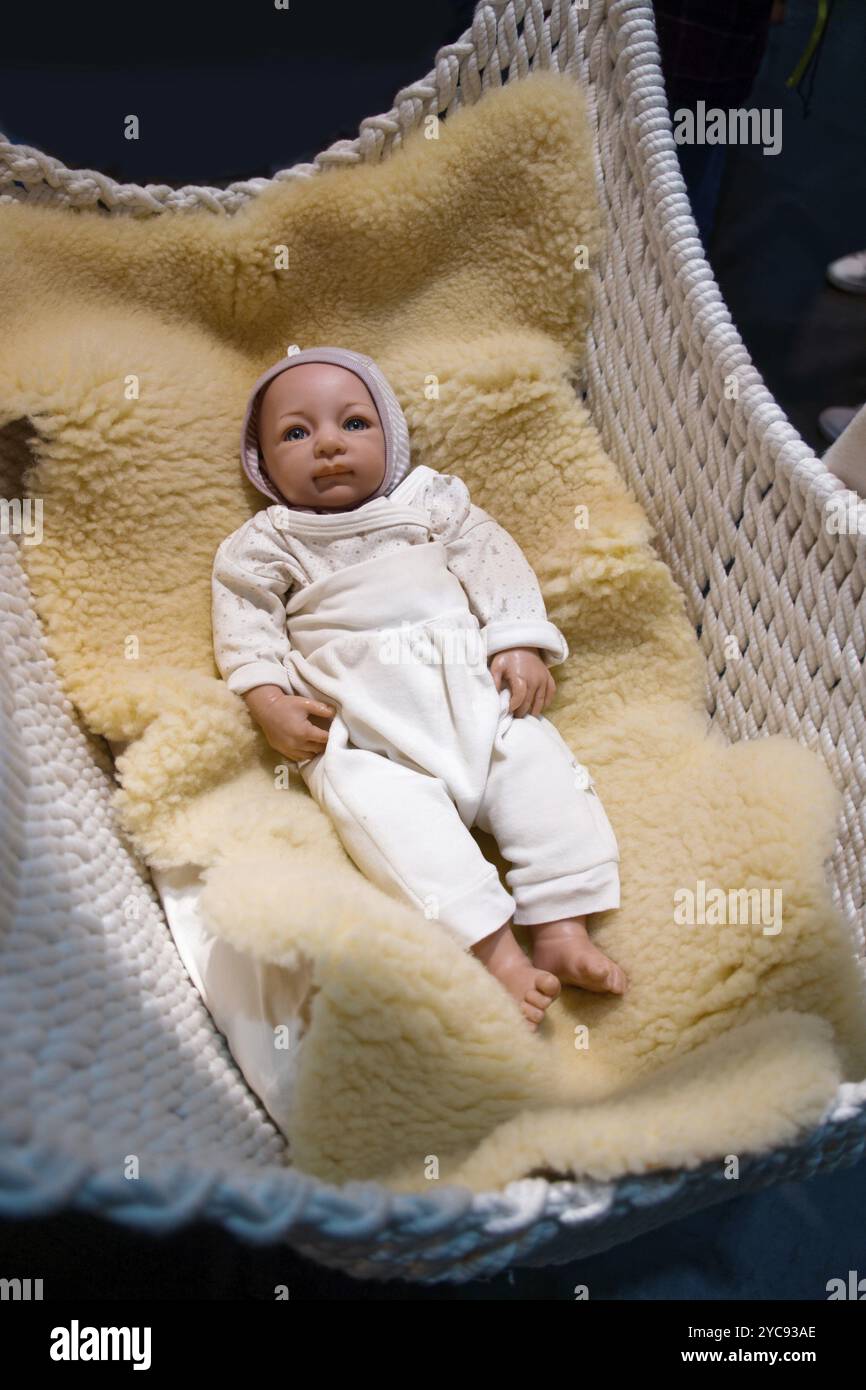 Life-size child doll in a hanging cradle Stock Photo - Alamy