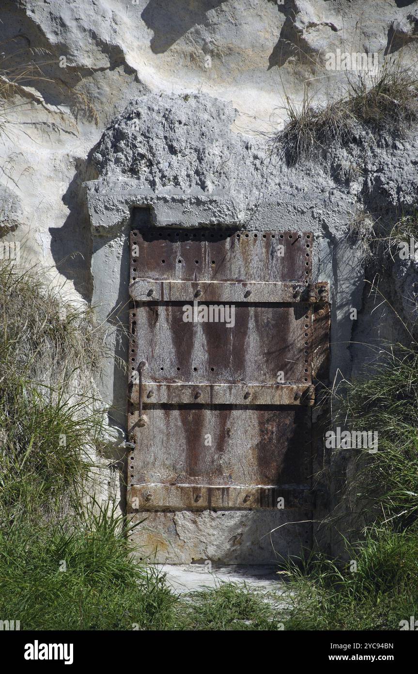 Old iron door set in a cliff face, Dunedin, South Island, New Zealand ...